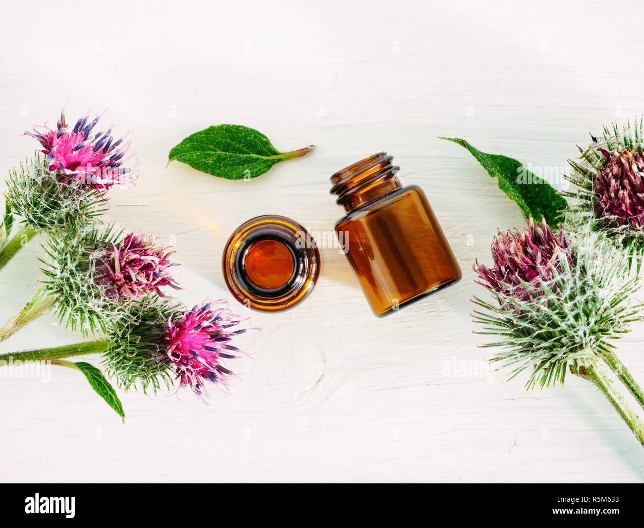 burdock oil in small glass bottle, top view, copyspace Stock Photo - Alamy
