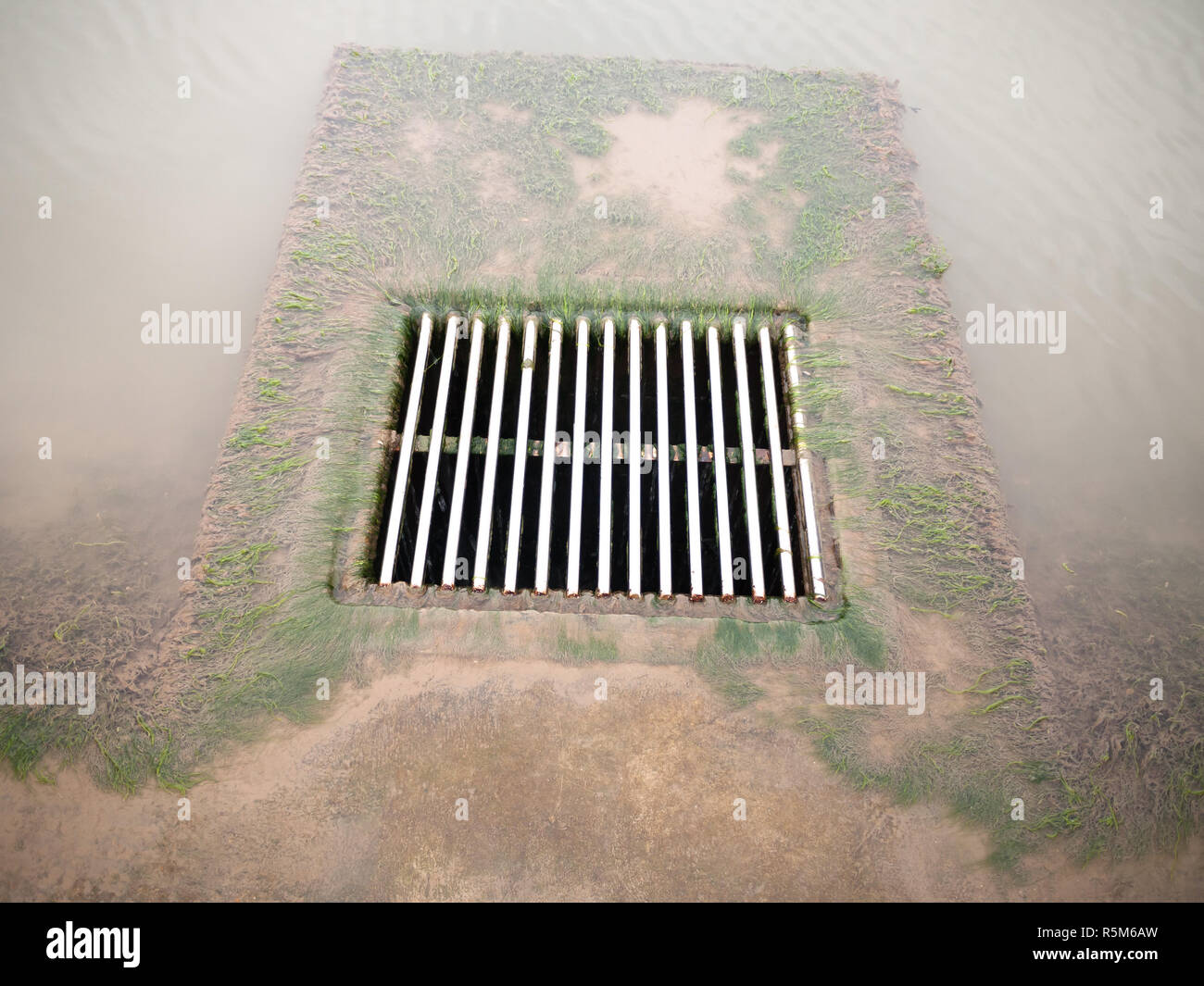 metal water grid with water running into it on ground clear Stock Photo ...