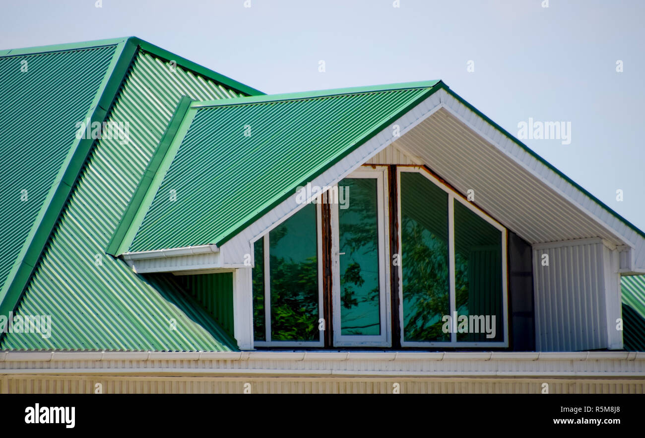 The house with plastic windows and a green roof of corrugated sheet ...