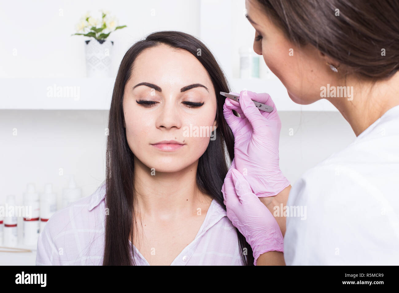 Forming eyebrows shape. Cosmetic procedures in cosmetology office Stock ...