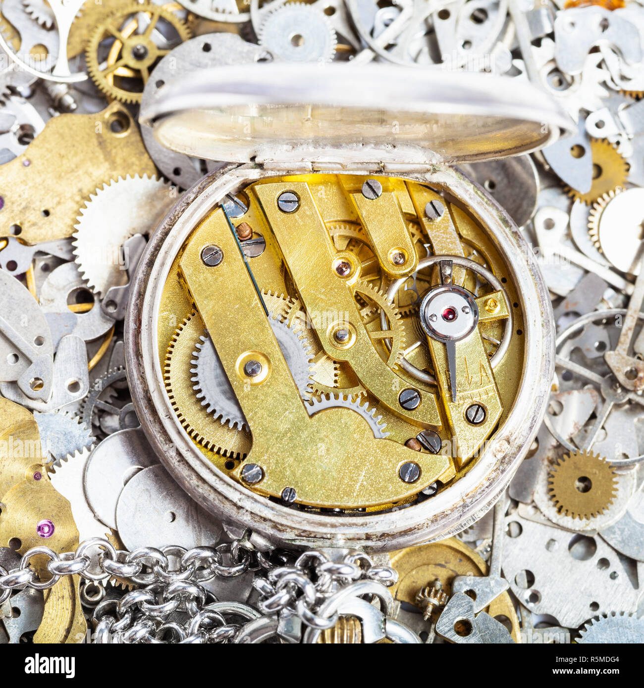 open retro pocket watch on pile of spare parts Stock Photo - Alamy