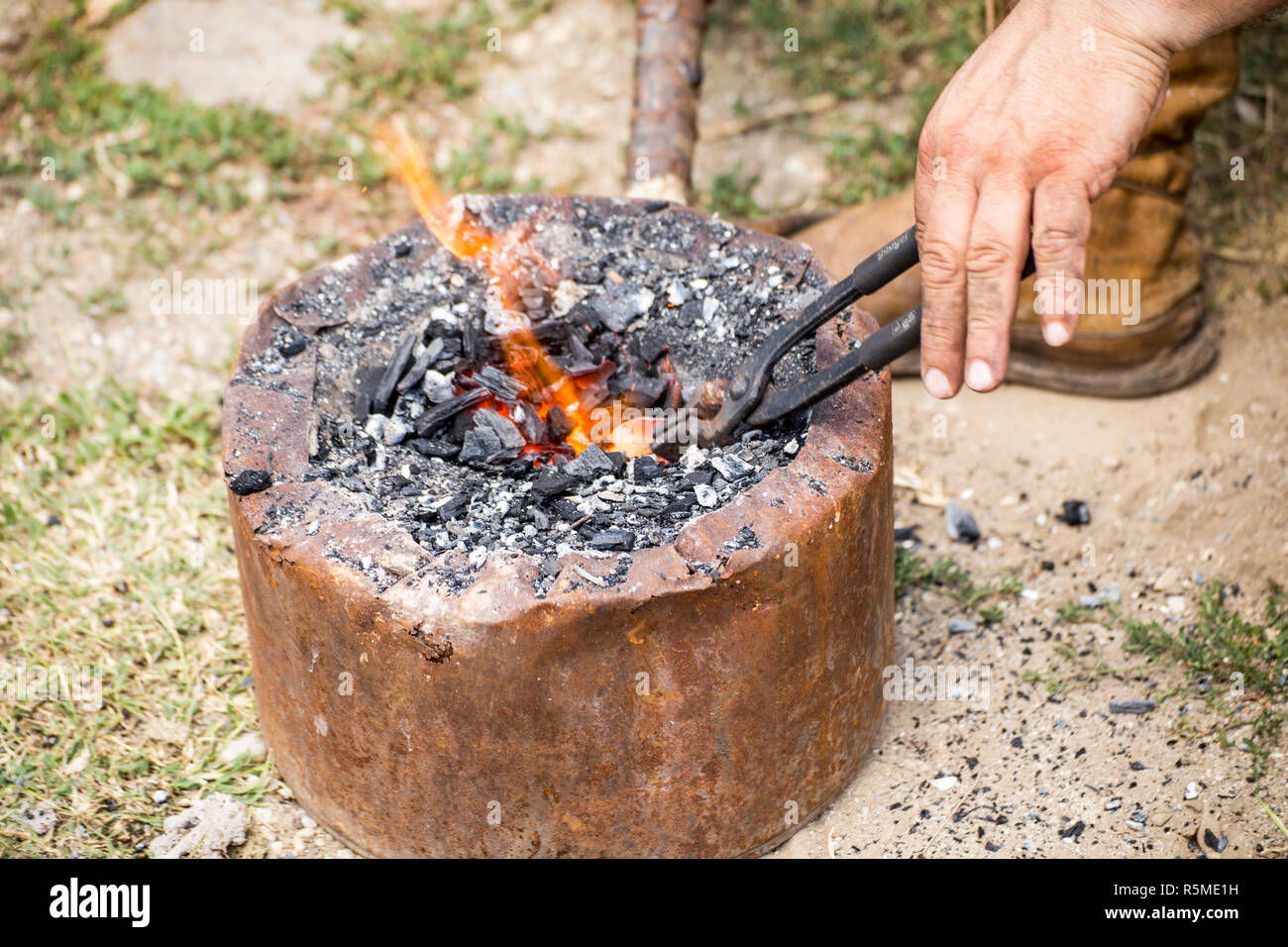 Blacksmith melting a piece of metal in a small forge Stock Photo - Alamy