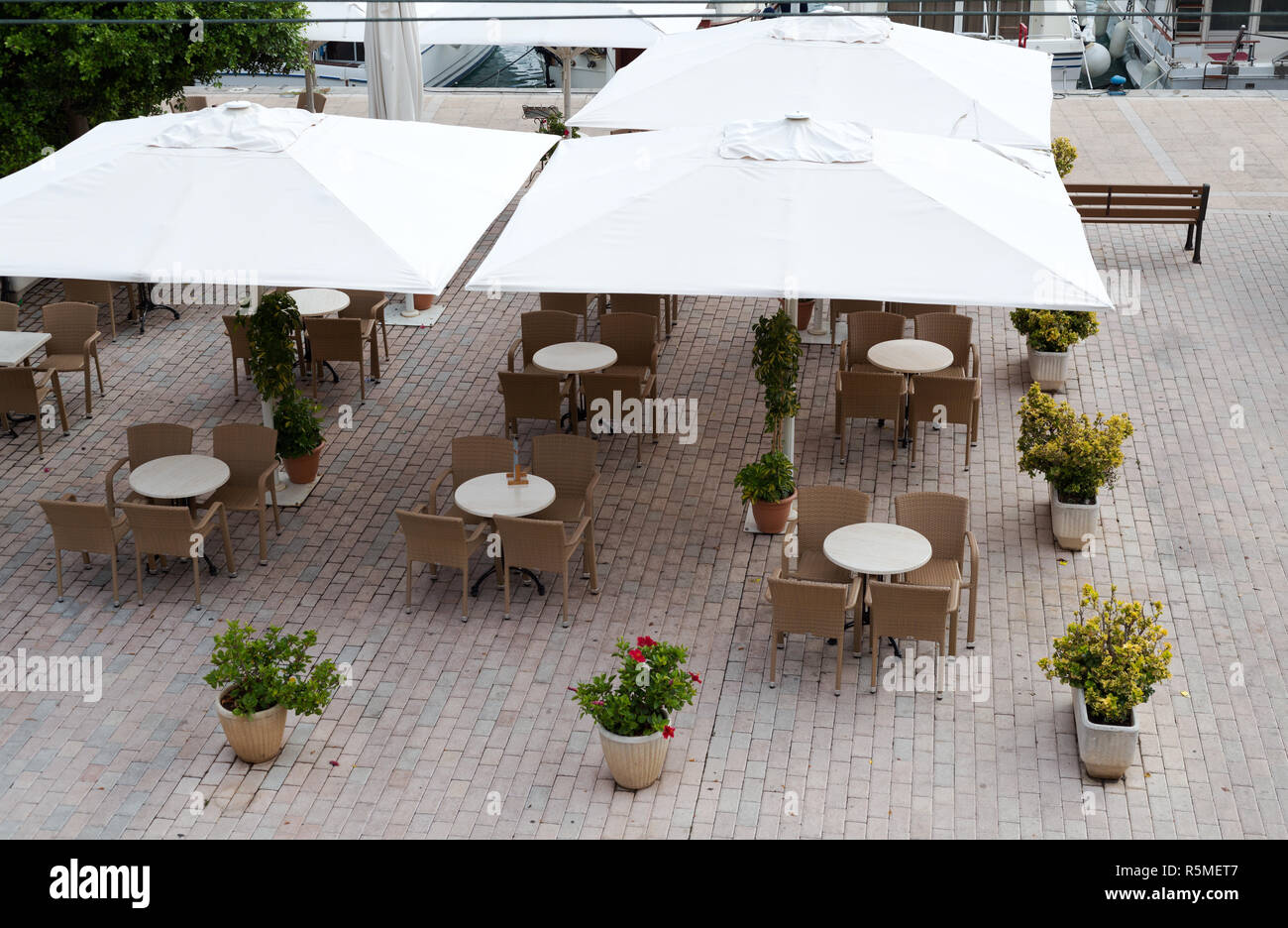 An empty restaurant on the pavement with large umbrellas Stock Photo ...