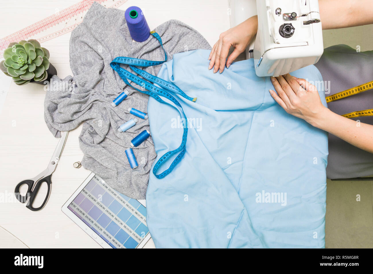 Sewing workshop. Seamstress at work. Young woman working with sewing ...