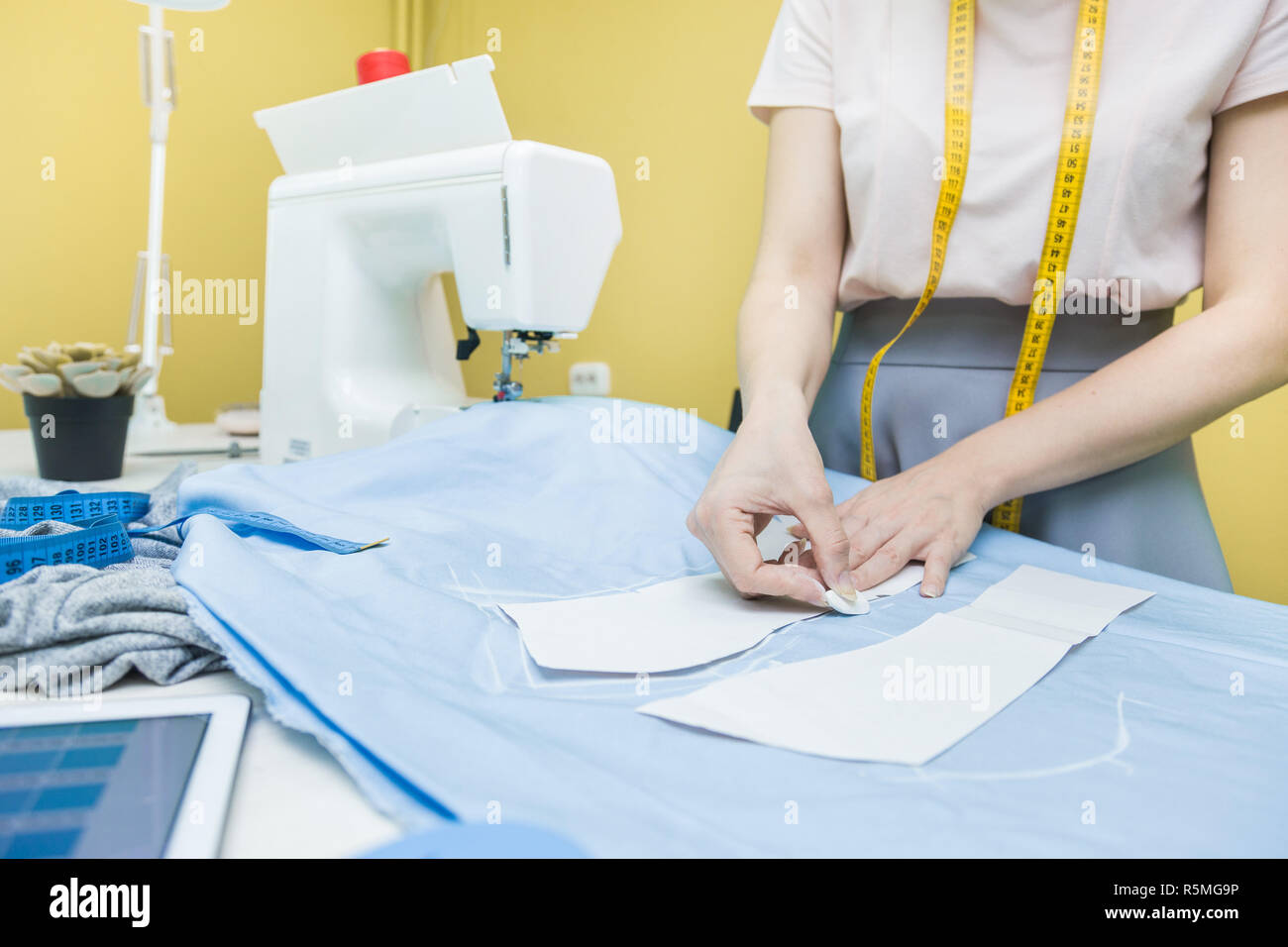 Sewing workshop. Seamstress at work. Marking and cutting fabric Stock ...