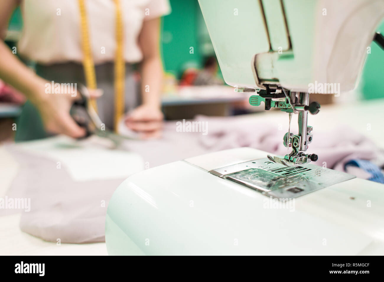 Sewing workshop. Seamstress at work. Marking and cutting fabric Stock ...