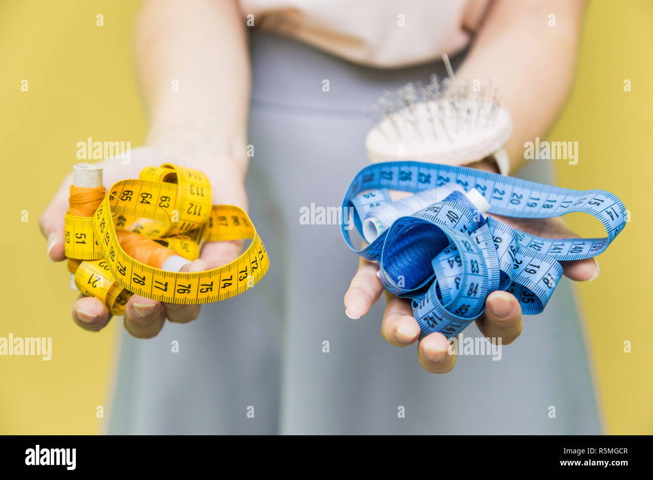 Sewing workshop. Seamstress at work. Closeup of hands holding a ...