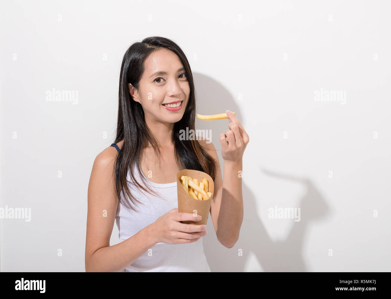 Woman eating french fries Stock Photo - Alamy
