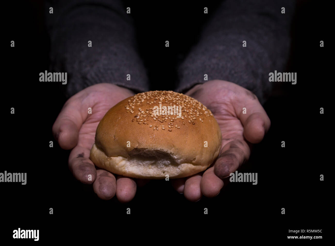Poverty concept. Dirty hands giving bread isolated on balck background ...