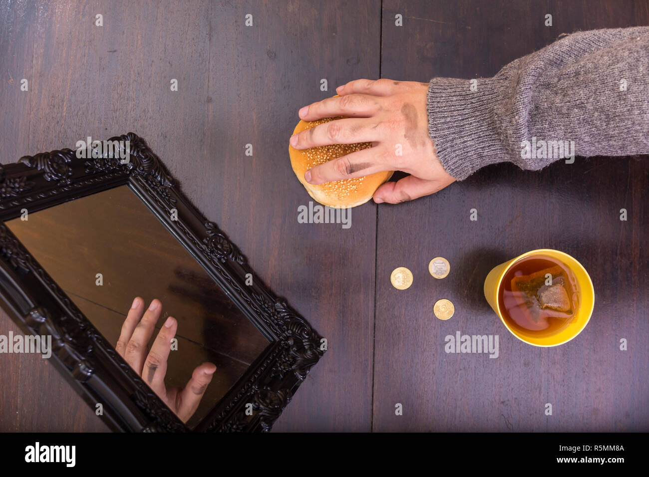 Human hand taking bread from a worn out table. Poverty concept. No ...