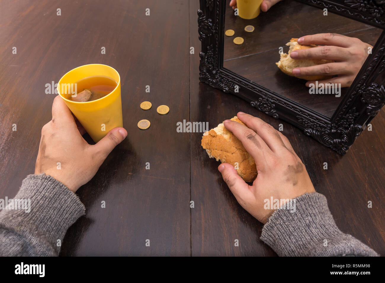 Human hand taking bread from a worn out table. Poverty concept. No ...