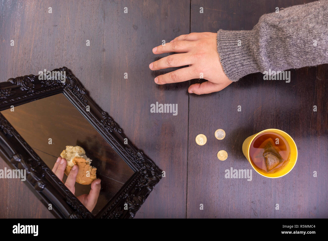 Human hand taking bread from a worn out table. Poverty concept. No ...