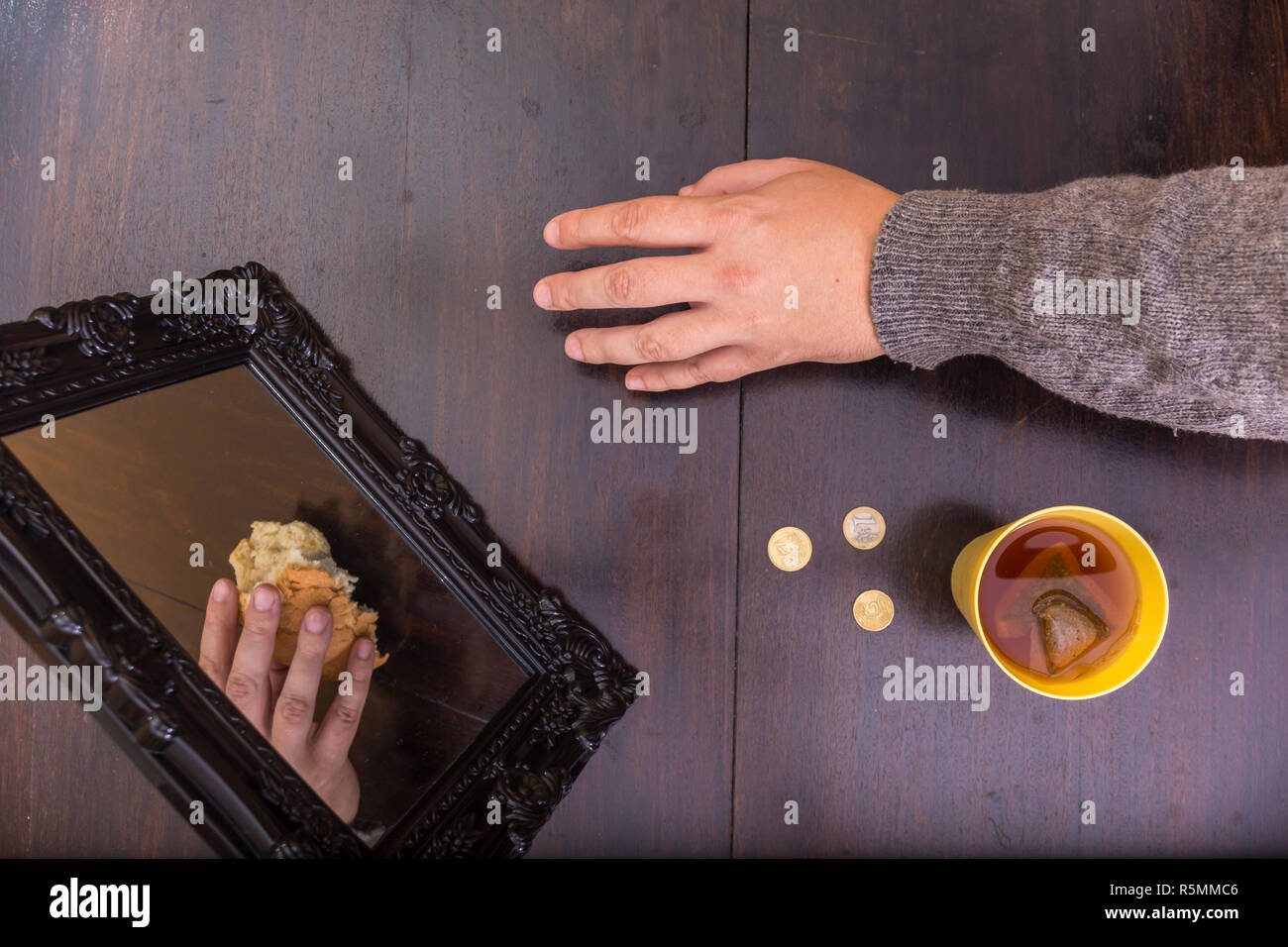 Human hand taking bread from a worn out table. Poverty concept. No ...