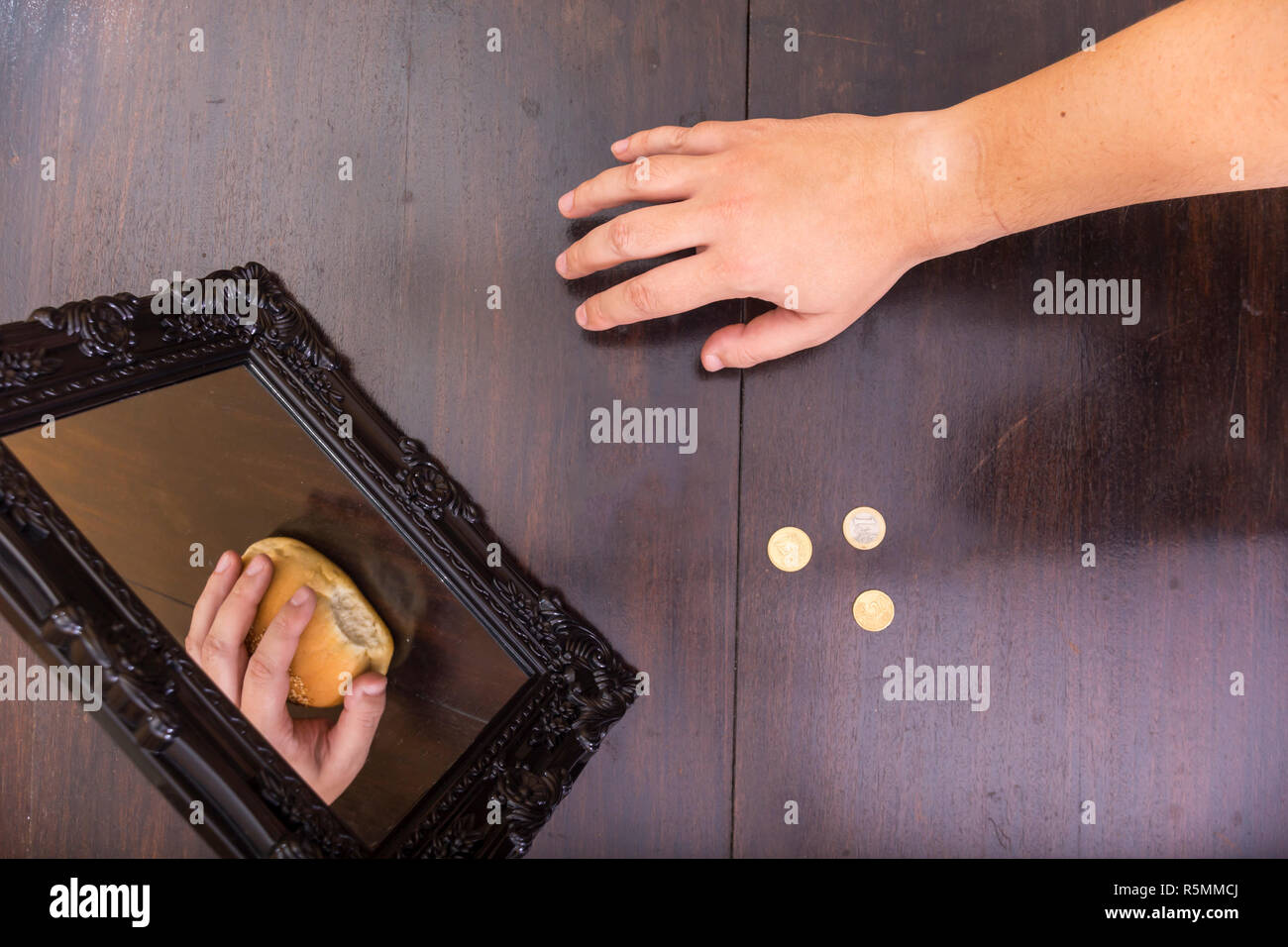 Human hand taking bread from a worn out table. Poverty concept. No ...