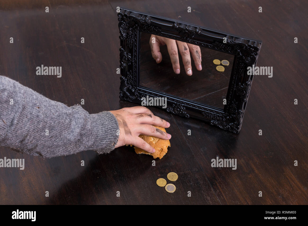 Human hand taking bread from a worn out table. Poverty concept. No ...