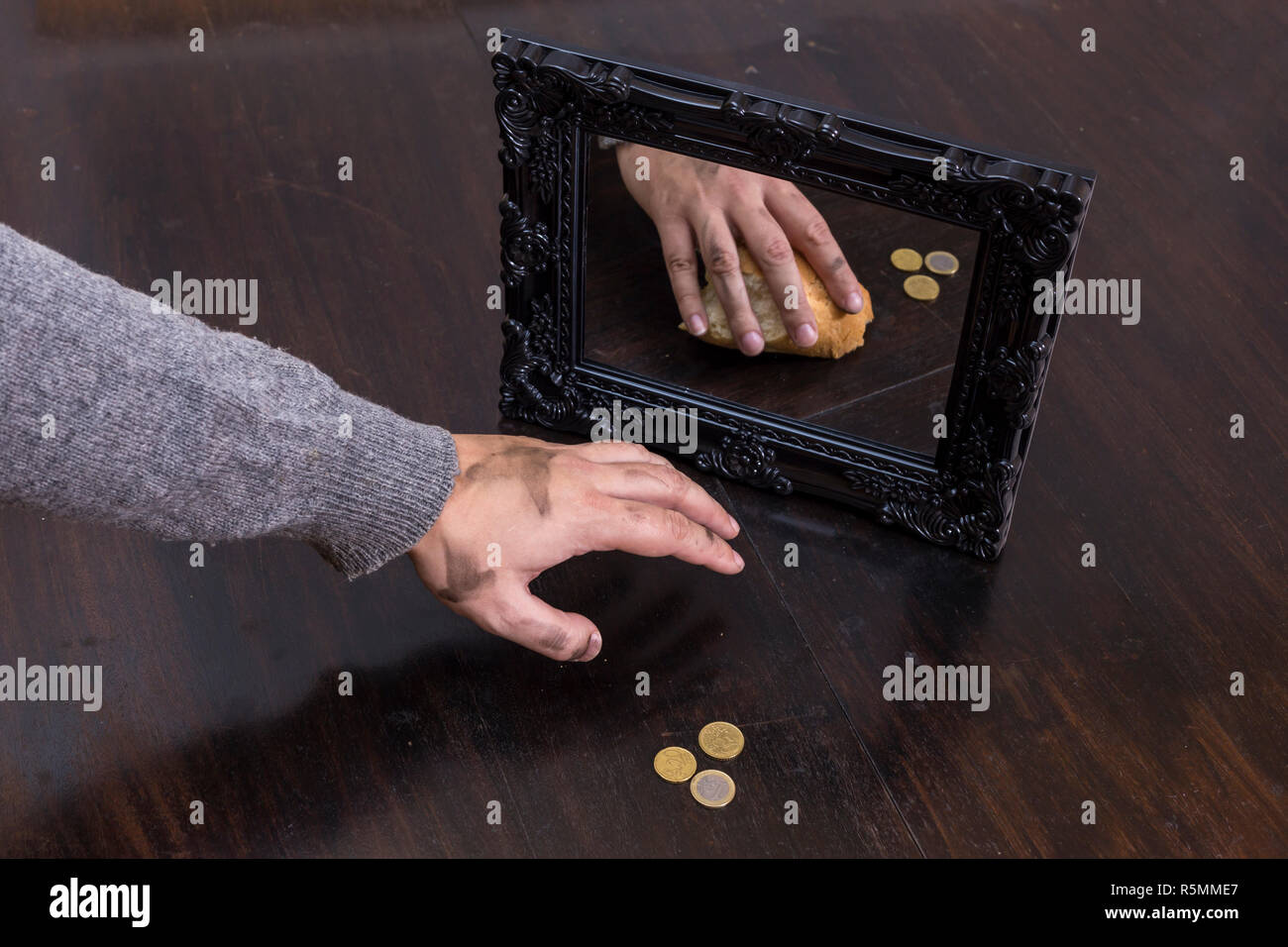 Human hand taking bread from a worn out table. Poverty concept. No ...