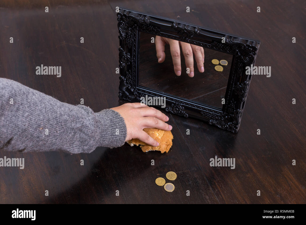 Human hand taking bread from a worn out table. Poverty concept. No ...