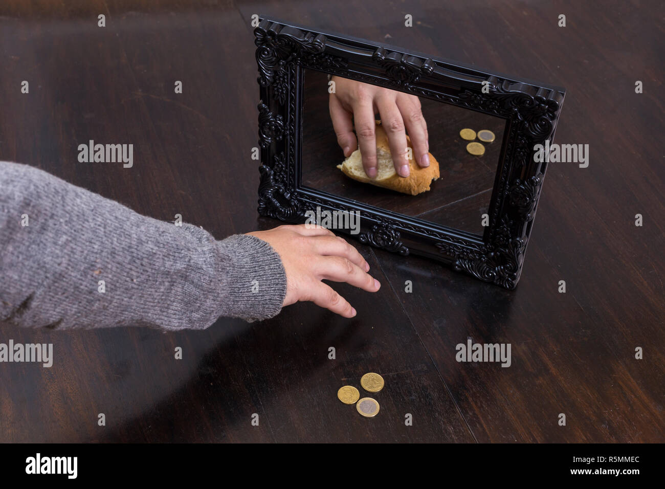 Human hand taking bread from a worn out table. Poverty concept. No ...