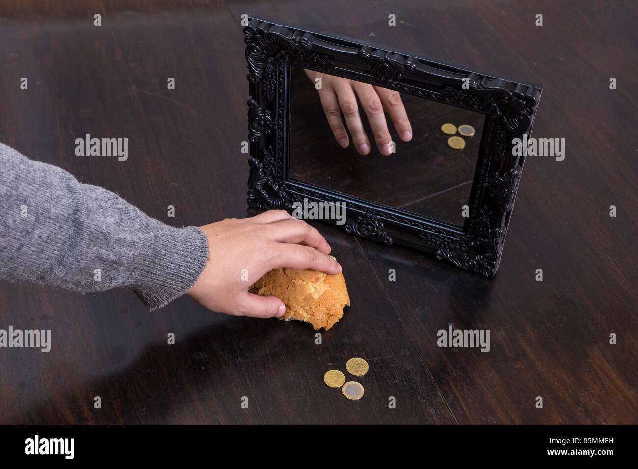 Human hand taking bread from a worn out table. Poverty concept. No ...