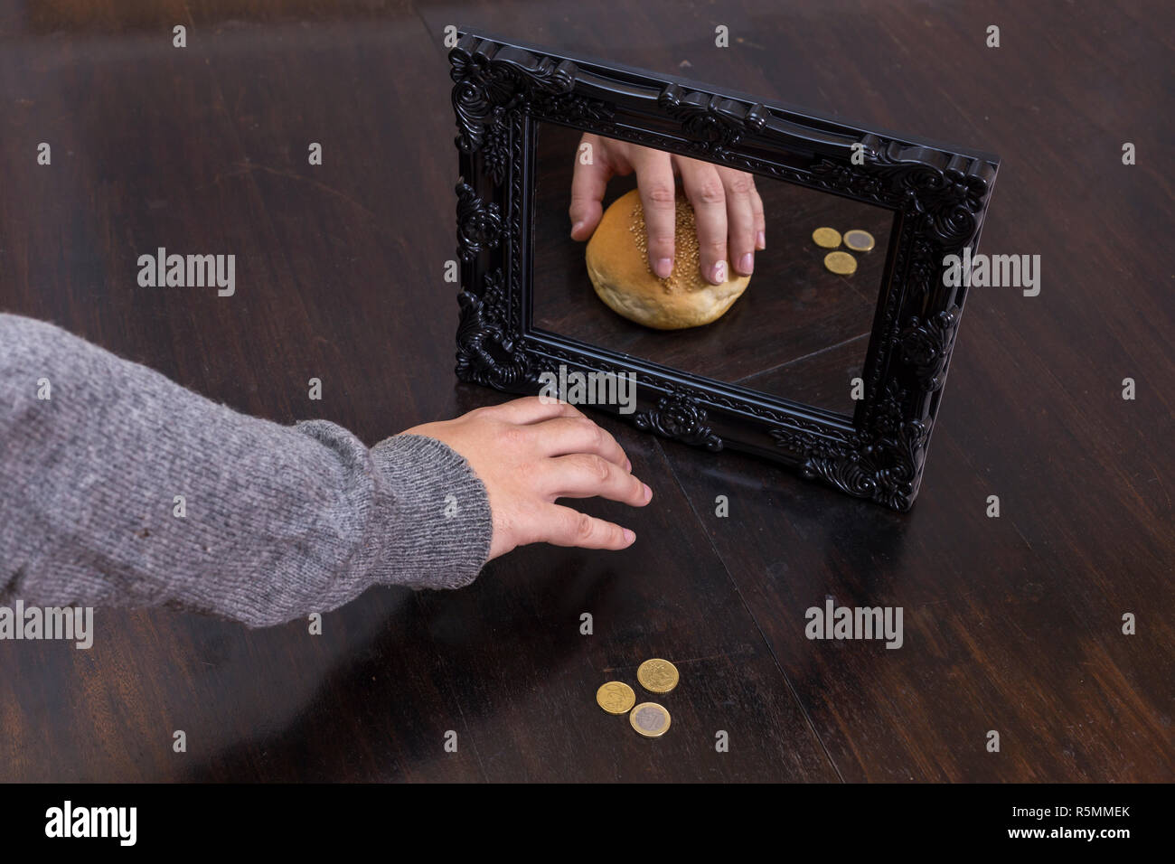 Human hand taking bread from a worn out table. Poverty concept. No ...