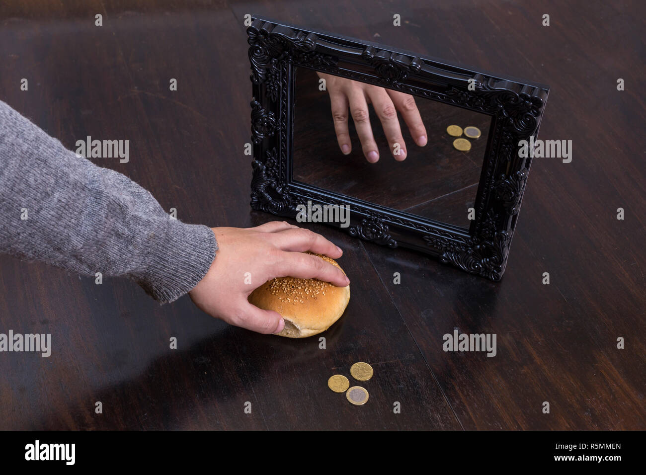 Human hand taking bread from a worn out table. Poverty concept. No ...