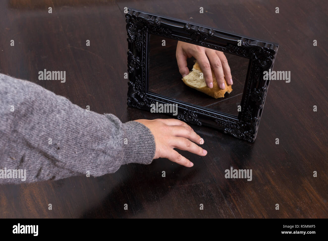 Human hand taking bread from a worn out table. Poverty concept. No ...