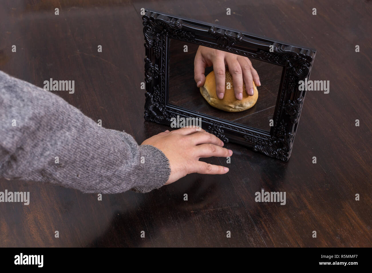 Human hand taking bread from a worn out table. Poverty concept. No ...