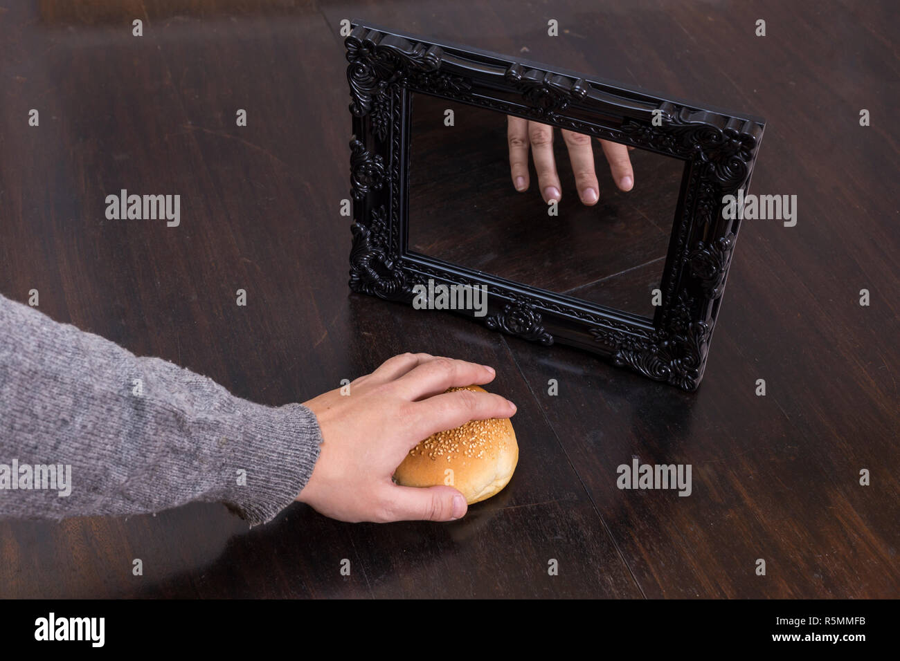 Human hand taking bread from a worn out table. Poverty concept. No ...