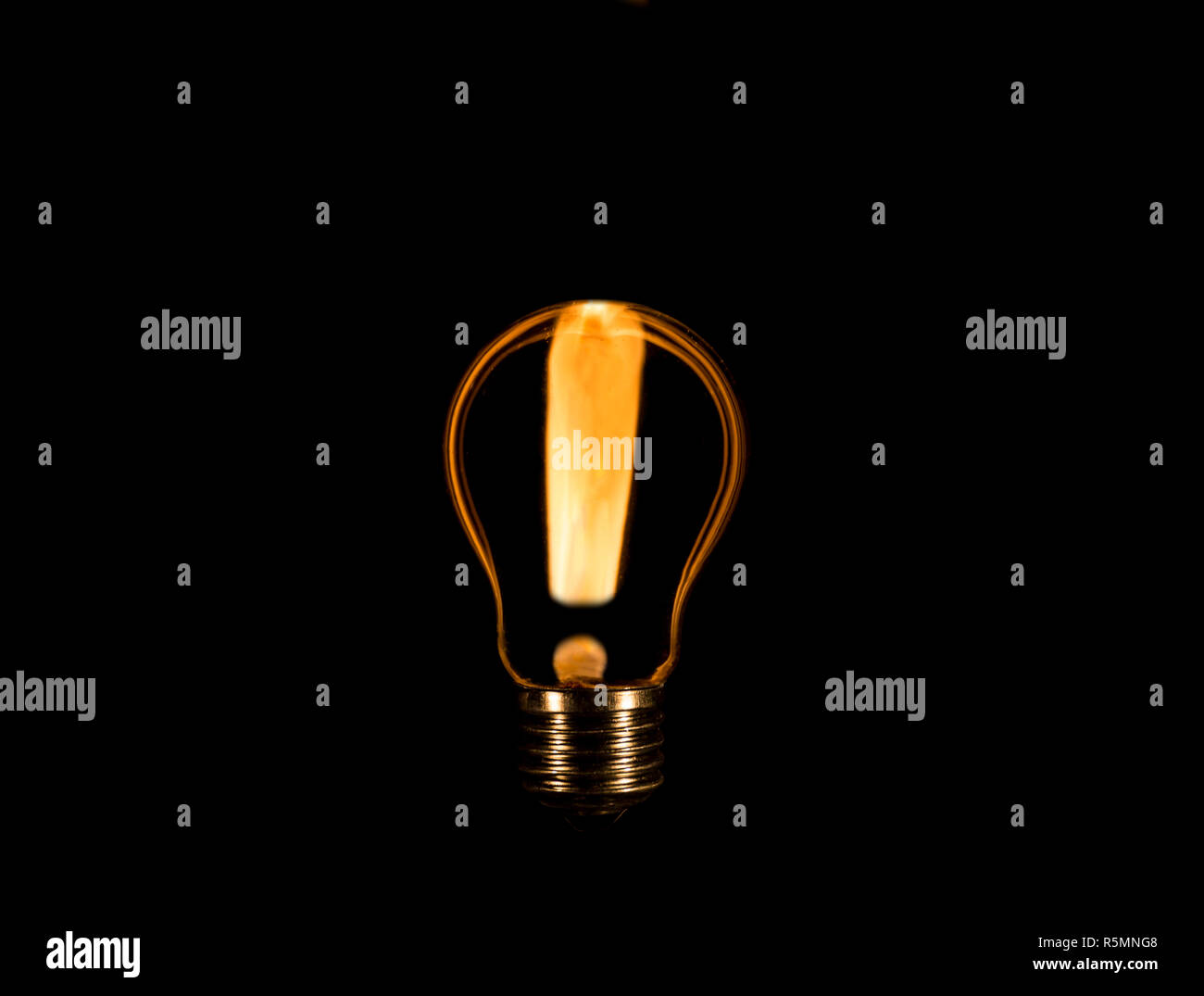 Exclamation point sign burning inside a light bulb isolated on black ...
