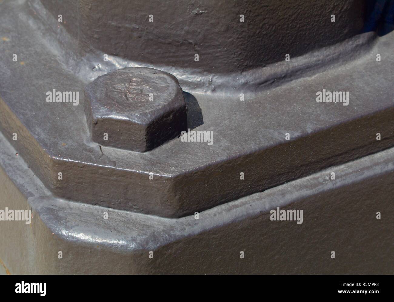 Large painted bolt head showing holding piece in place Stock Photo - Alamy