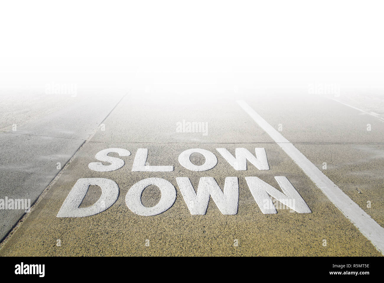 Big Slow Down sign on a footpath disappearing in white fog Stock Photo ...