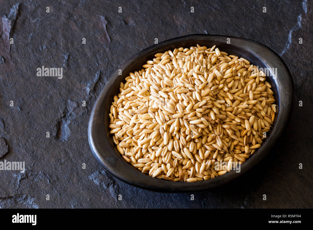 Oat (Avena sativa) grains in a traditional black clay dish Stock Photo ...