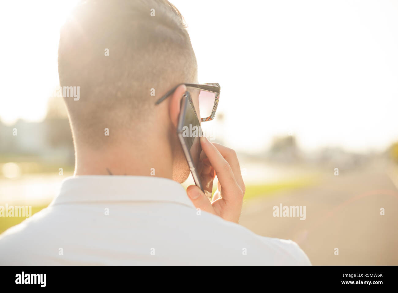 Man with mobile phone in hands, back view, outdoor Stock Photo - Alamy