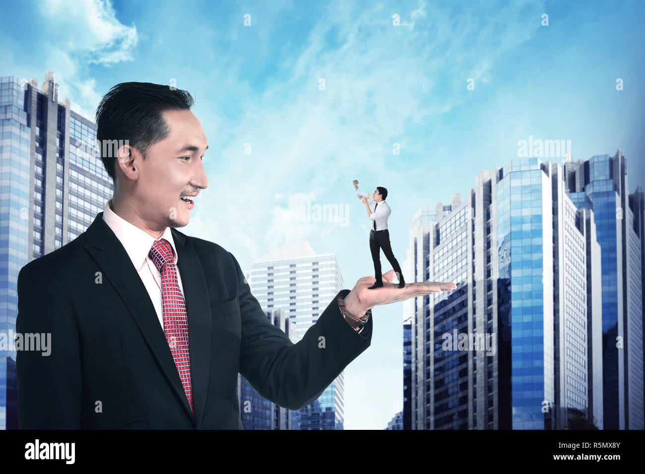 Giant businessman holding little man yelling with megaphone Stock Photo ...