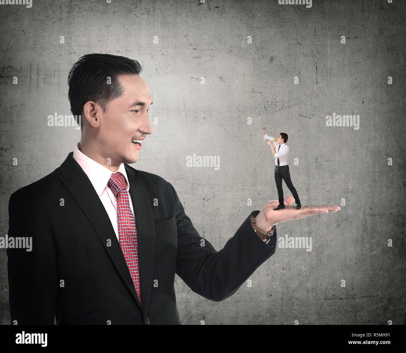 Giant businessman holding little man yelling with megaphone Stock Photo ...