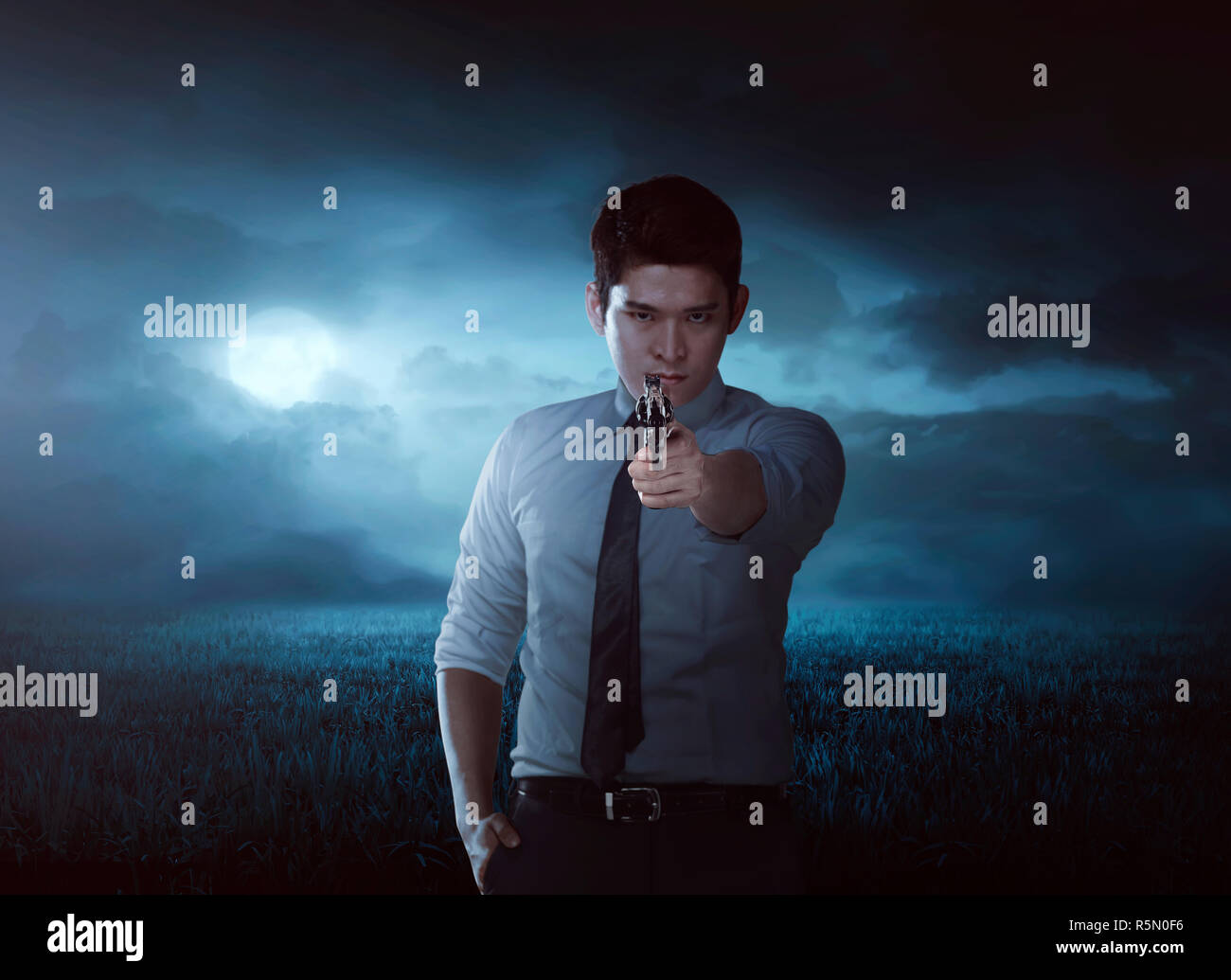 Asian man aiming gun Stock Photo - Alamy
