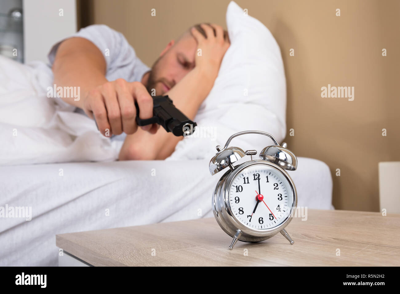 Man Holding Gun To Shoot Alarm Clock Stock Photo - Alamy
