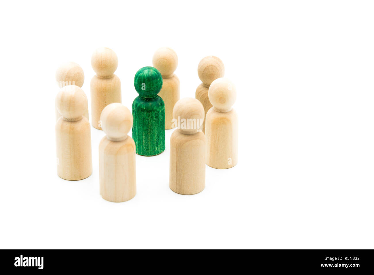 Green figure standing out from the crowd inside circle of wooden ...