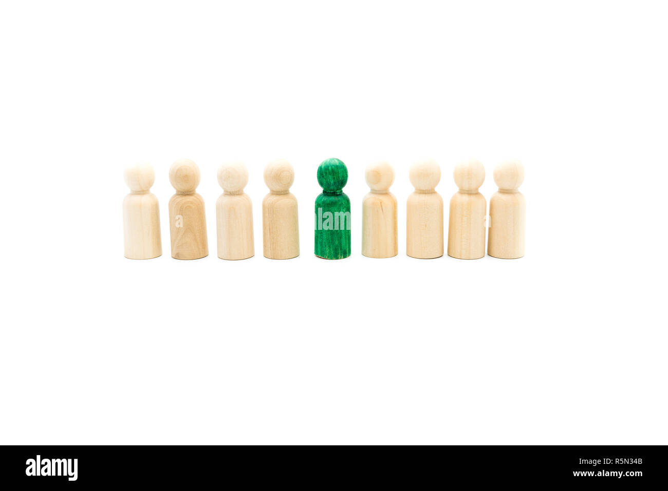 Wooden figures in line as business team, with one green figure standing ...