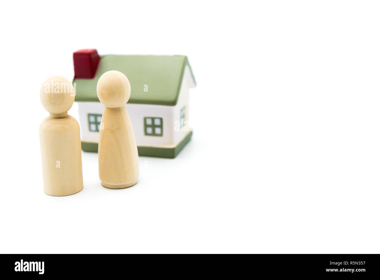 Wooden figures as family concept with house in the background, isolated ...