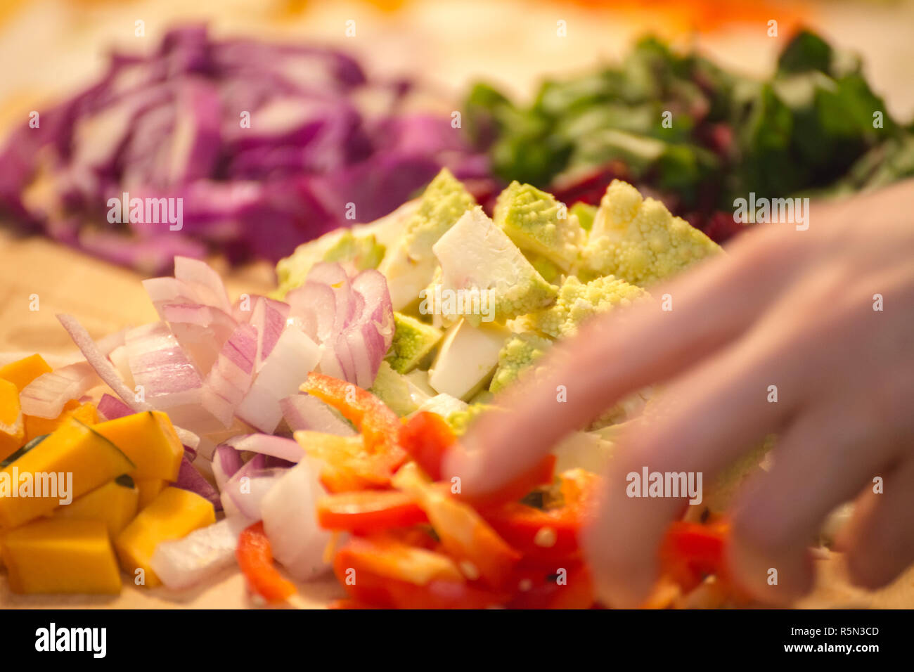 Piles of chopped vegetables on a wooden cutting board or chopping block ...