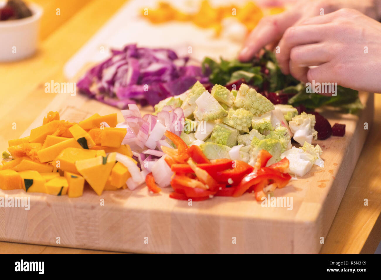 Piles of chopped vegetables on a wooden cutting board or chopping block ...