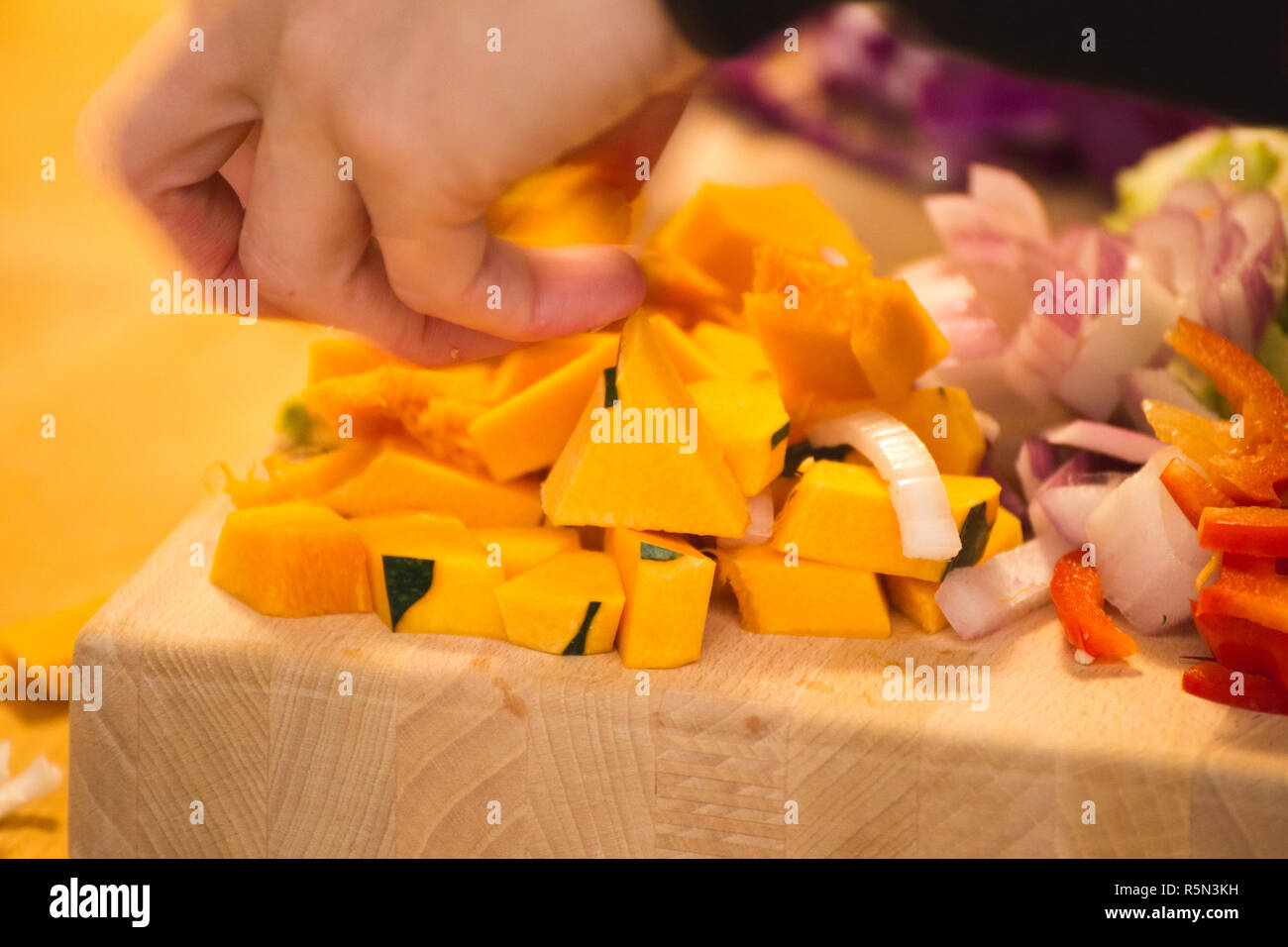Piles of chopped vegetables on a wooden cutting board or chopping block ...