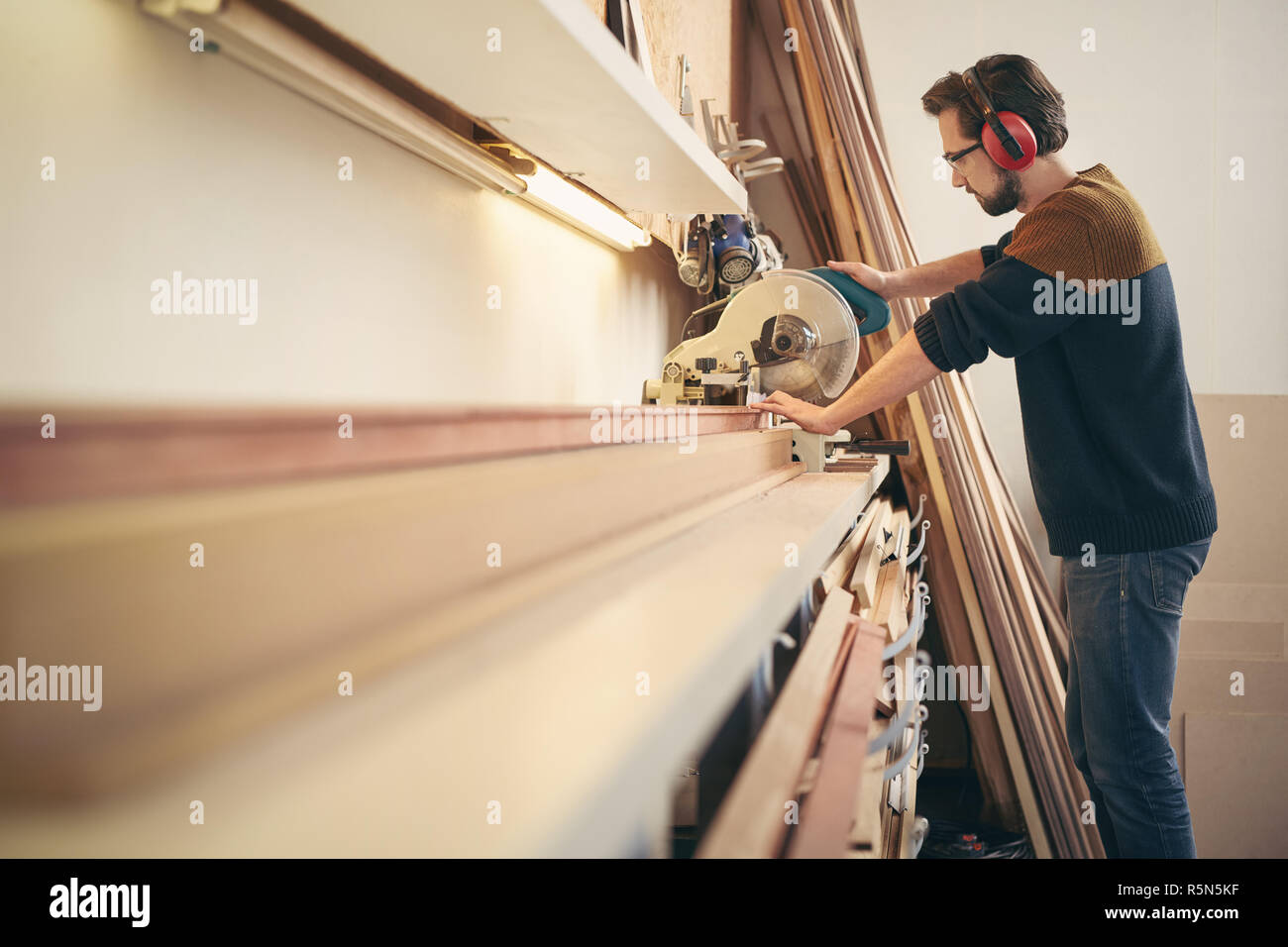 Professional framer using a work tool to saw through wood Stock Photo ...