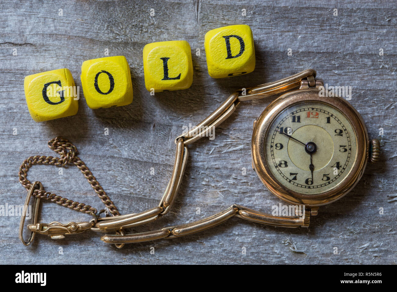 gold letter cube and clock on gray wood visualization Stock Photo - Alamy