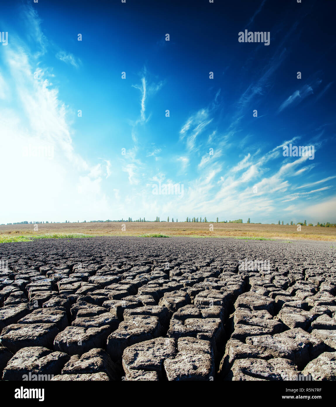 drought earth closeup and deep blue sky with clouds in sunset time ...