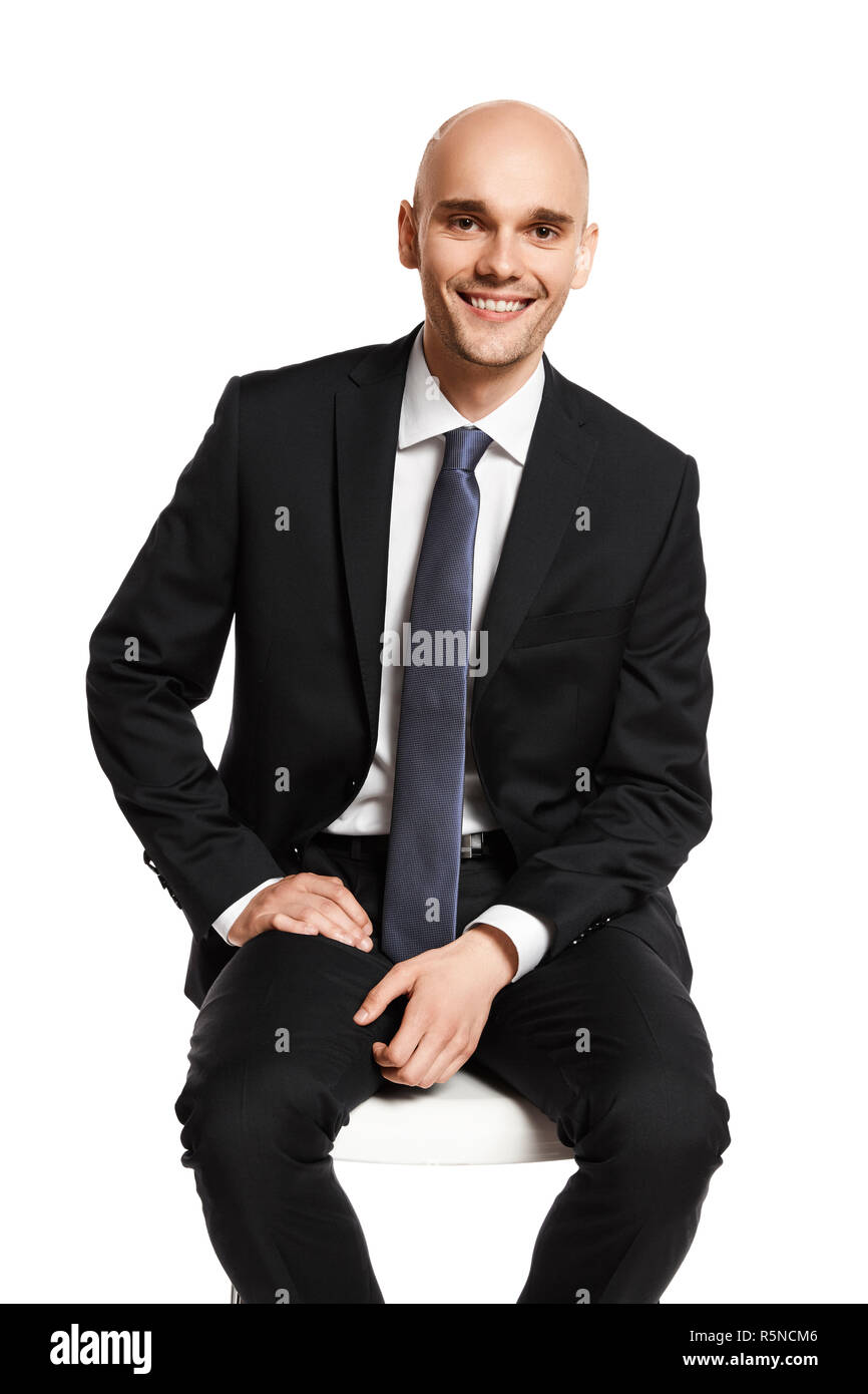 Young elegant man sitting on a chair Stock Photo - Alamy