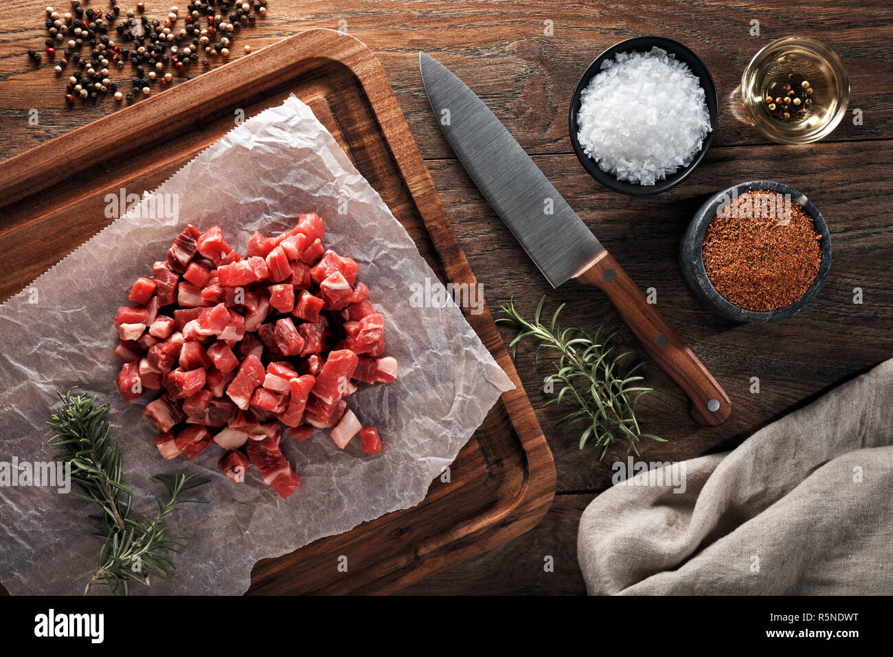 Raw calf meat chopped into small pieces on white cooking paper and ...
