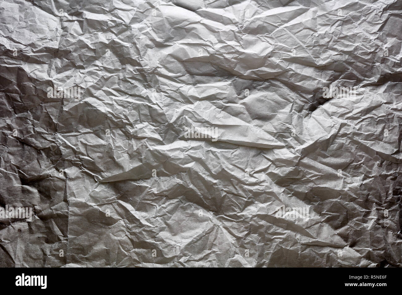 Wrinkled white paper texture background under dramatic dark moody ...
