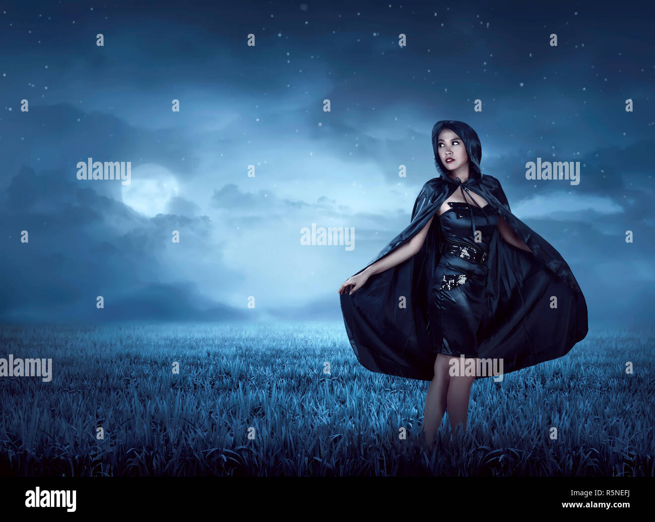 Beautiful witch woman with cloak hood Stock Photo - Alamy